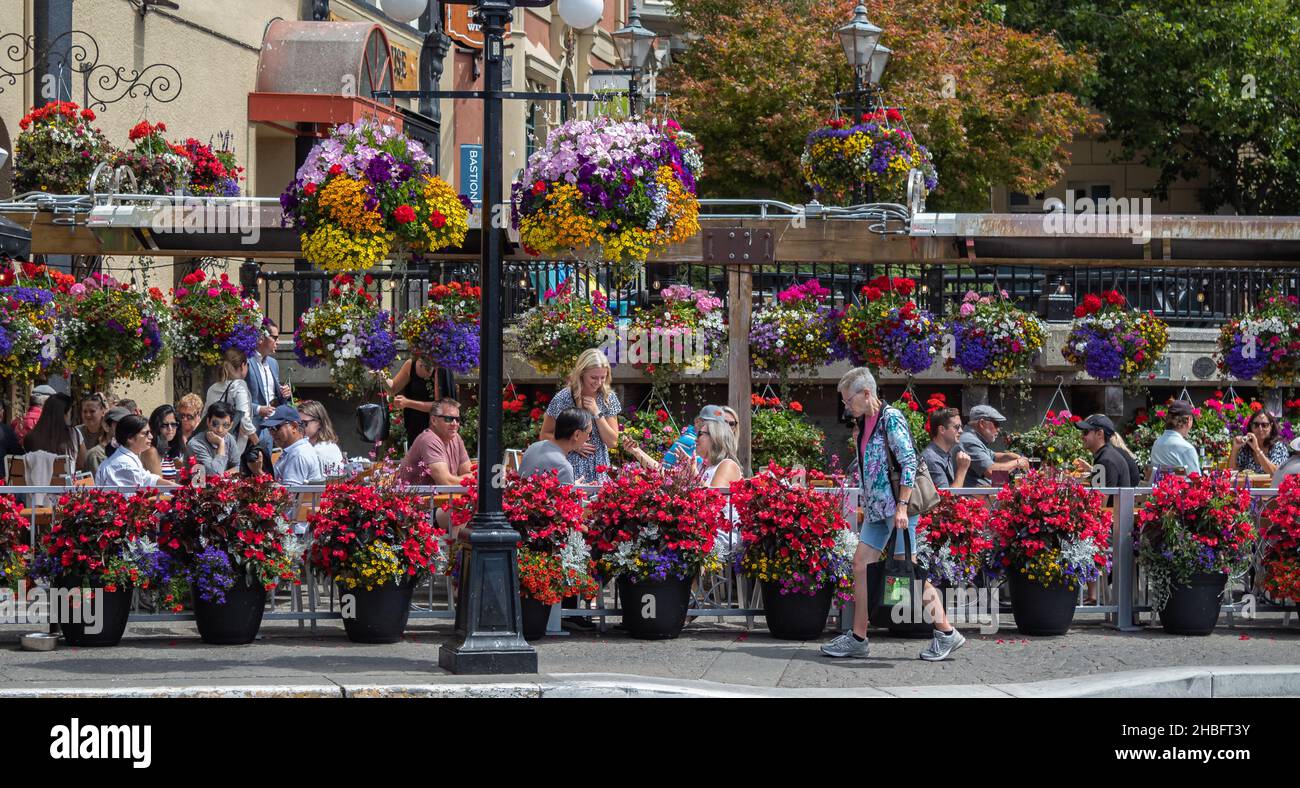 People sitting at street restaurant patio. Happy people eating local ...