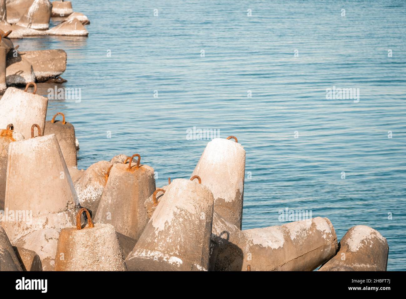 Coast breakwaters protecting from large waves with sea water background ...