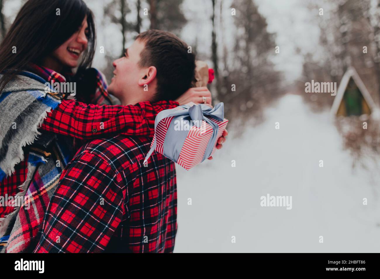 Boyfriend giving a gift box present with ribbon outdoor due to Saint ...