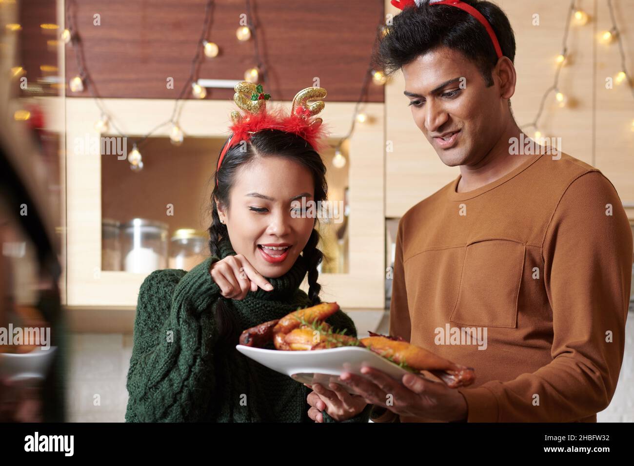 Couple looking at grilled chicken they cooked for Christmas dinner for ...