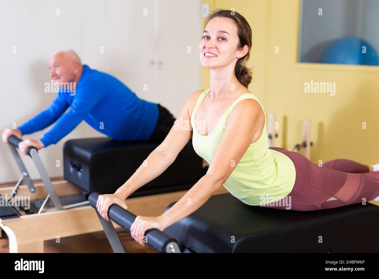 Woman doing pilates exercises lying on pilates machines Stock Photo - Alamy