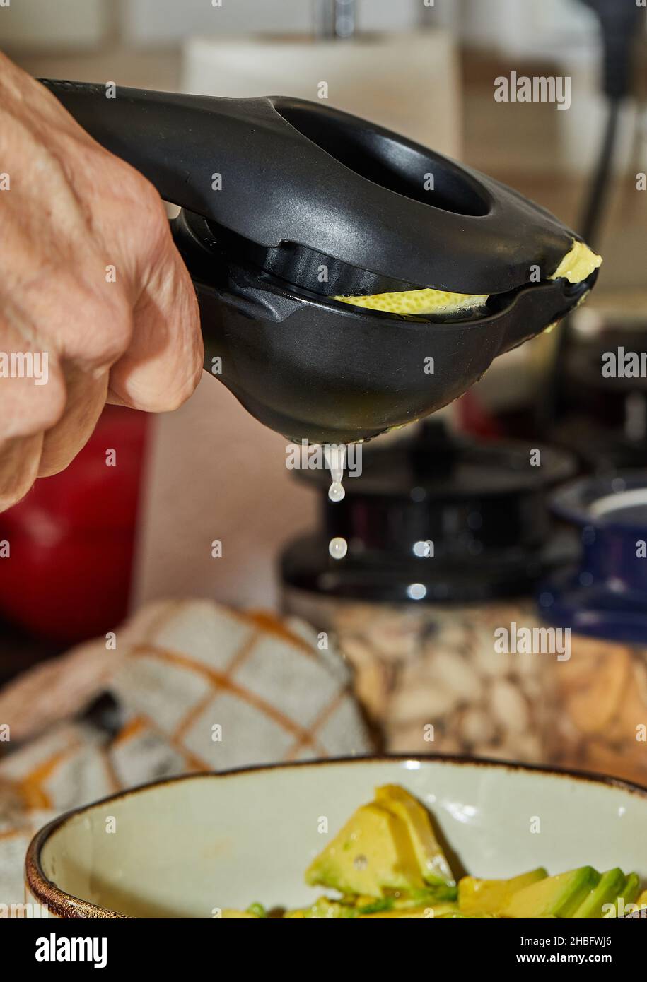 Cook squeezes lemon juice into salad using a special device for ...