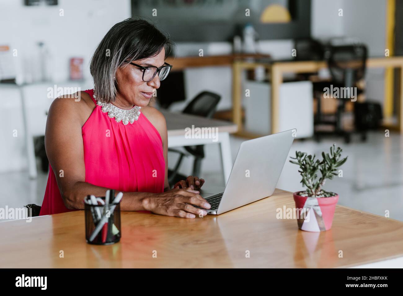 transgender latin woman working with computer at the office in Mexico ...