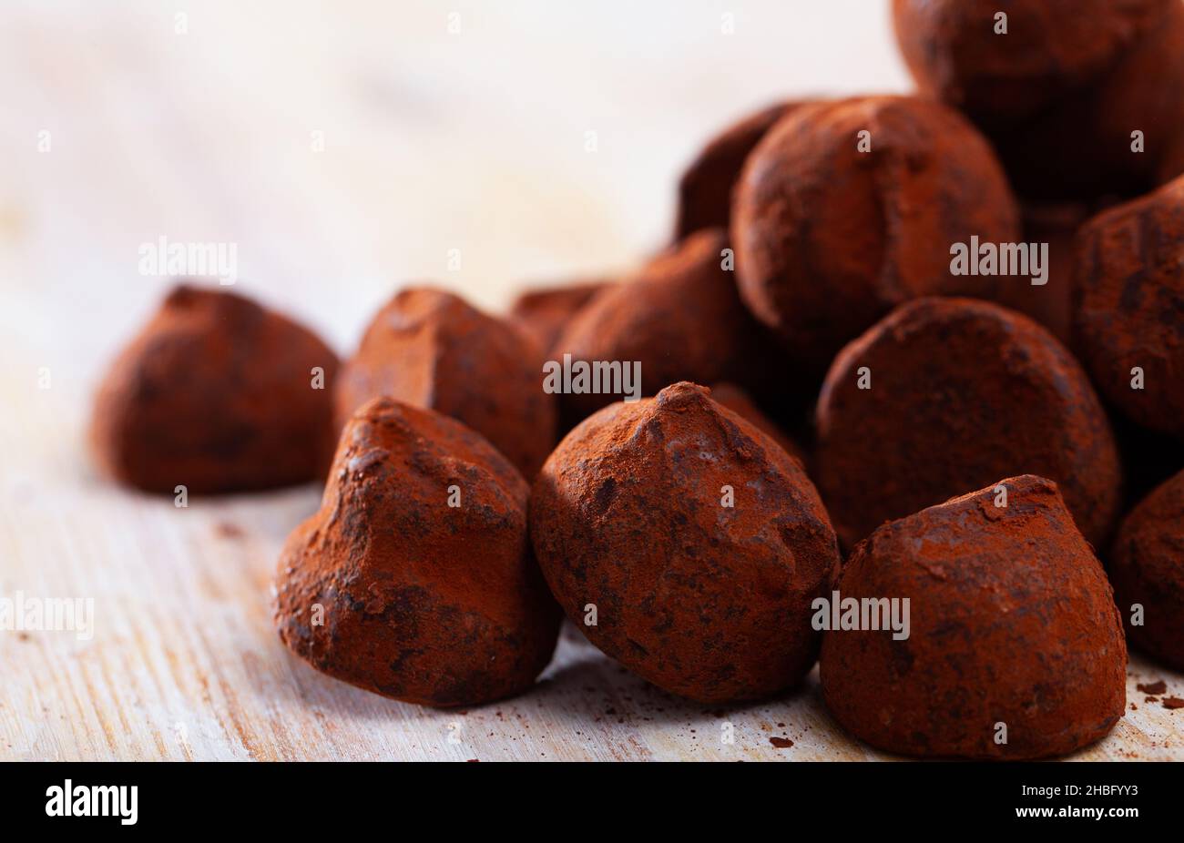 Dessert truffles sprinkled with cocoa on wooden table Stock Photo - Alamy