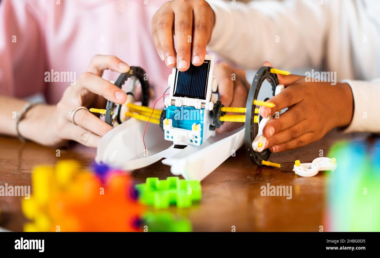Close up of unrecognizable Kids busy making DIY robot by looking from ...