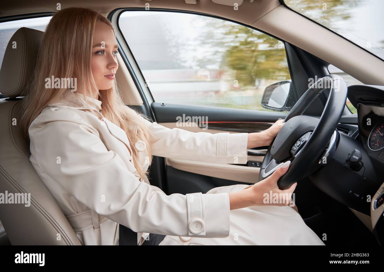 Beautiful young woman driving modern car. View from inside a car ...