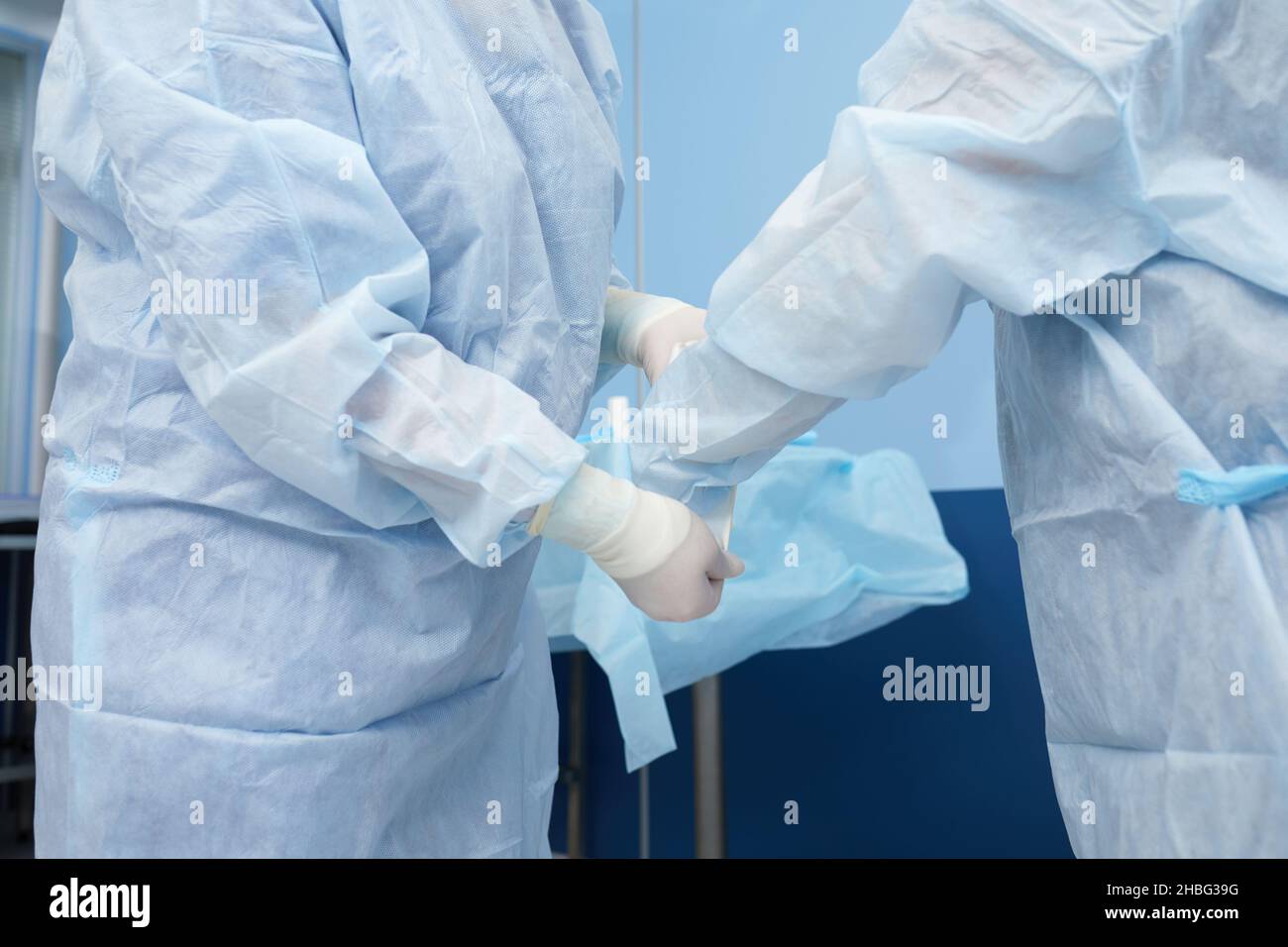 Surgeon and the nurse are preparing for surgery in the operating room ...