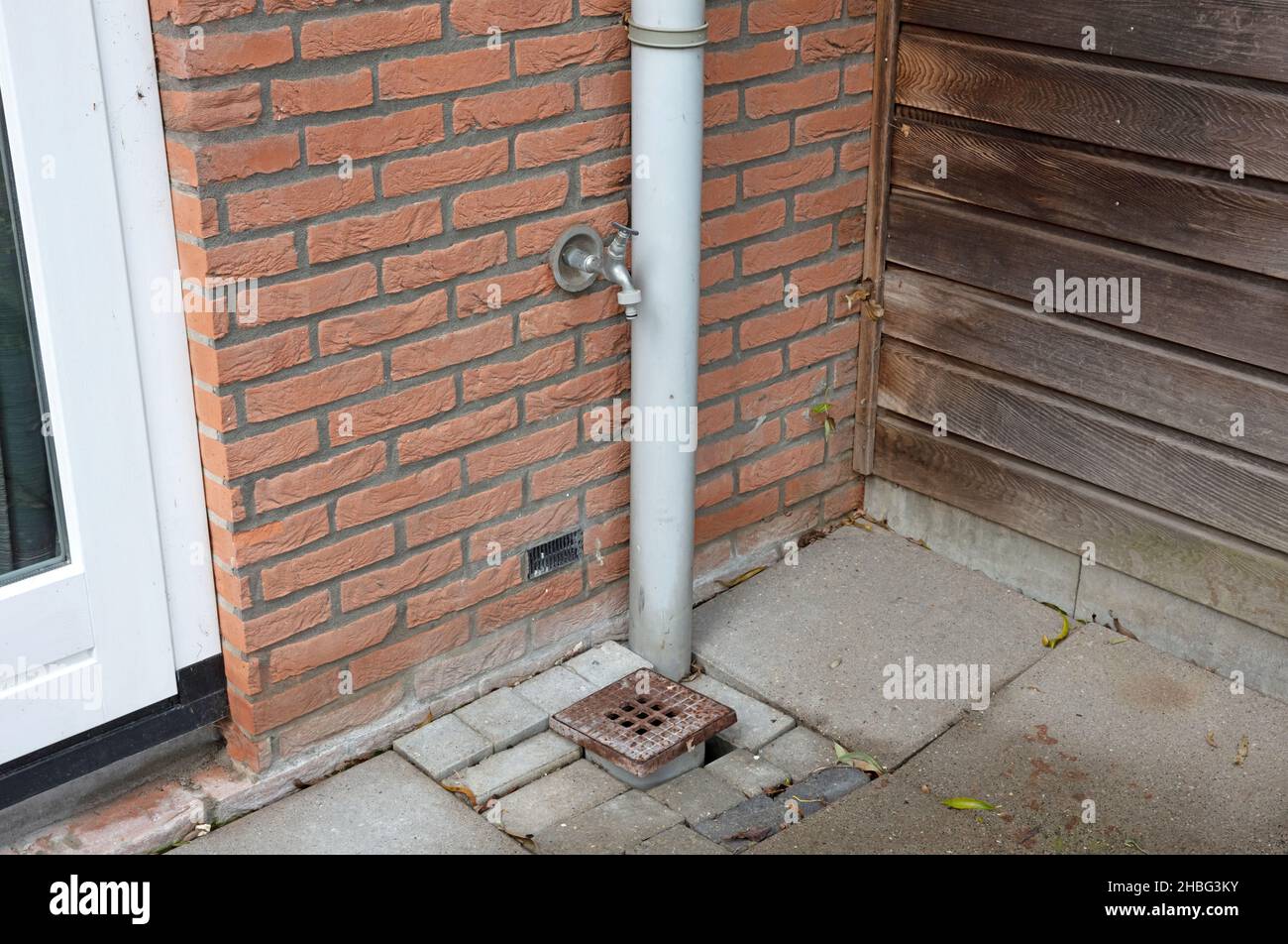 Outside tap mounted on a brick wall, ready to be used Stock Photo - Alamy