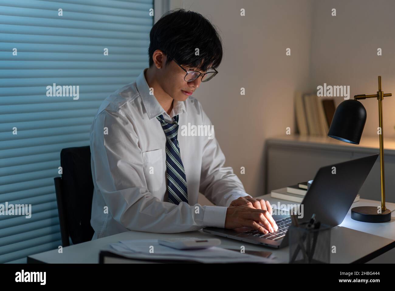 Overwork Concept The man sitting at his desk and focusing on working ...