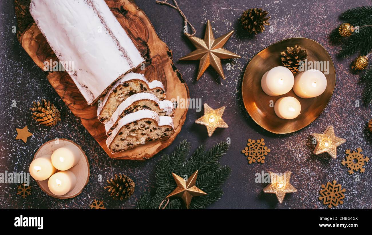 Christmas Stollen cake and golden decor on dark table. Christmas ...