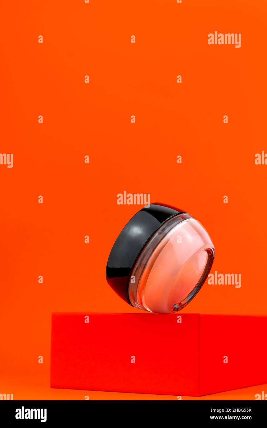 Cosmetic tonal foundation glass jar mockup on geometrical podium orange ...