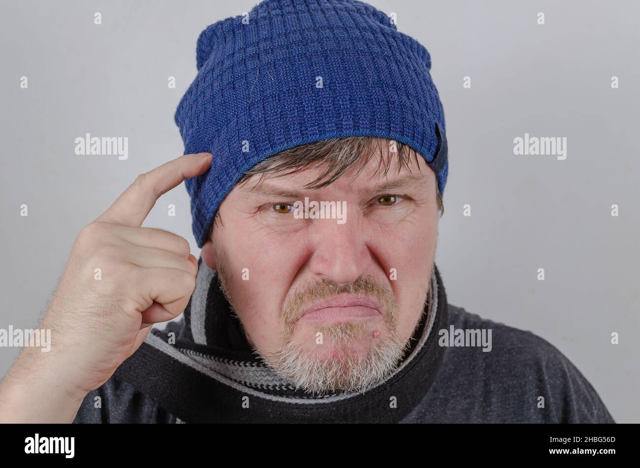 A portrait of an angry adult male against a bright wall. Adult man in a ...