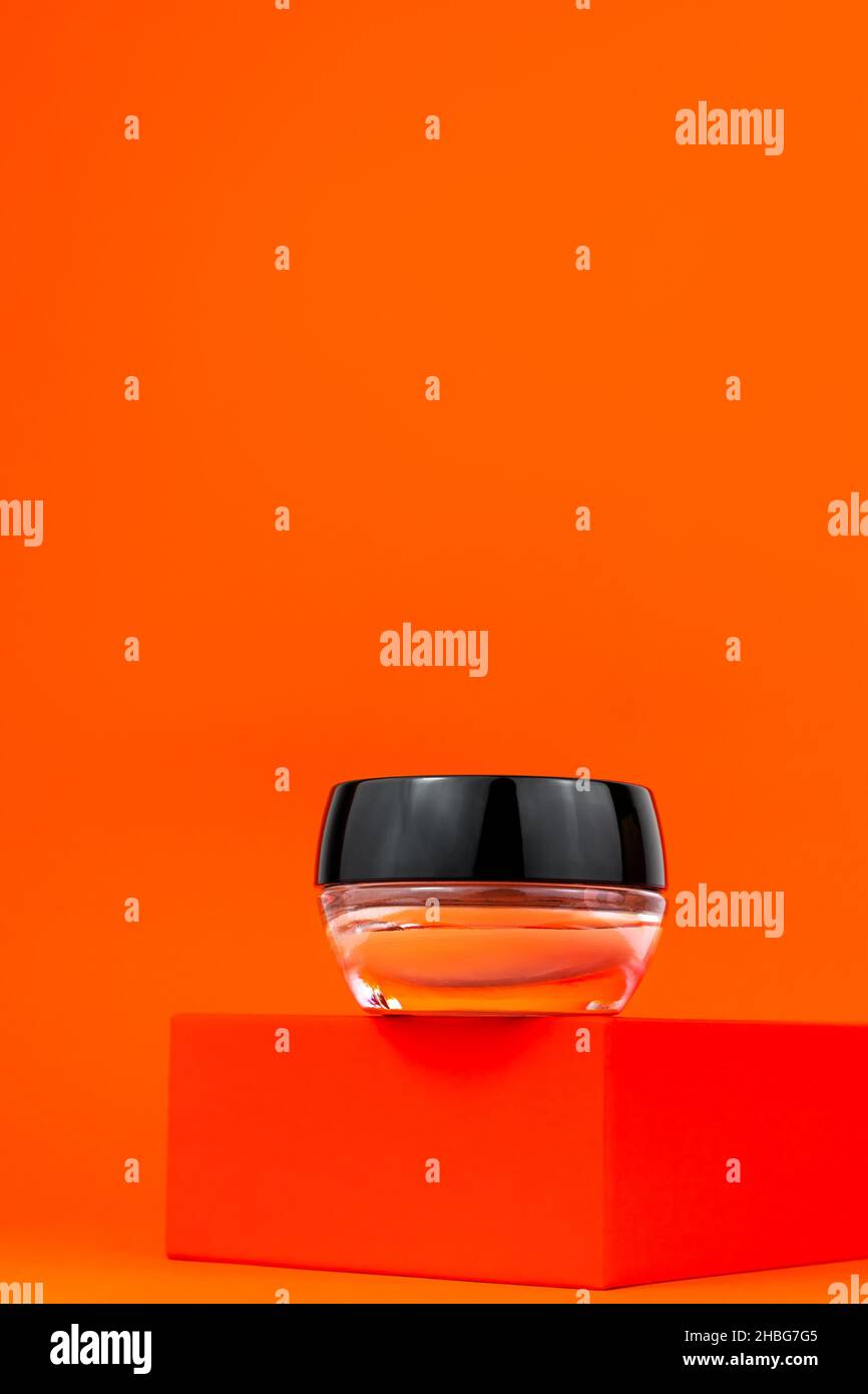 Cosmetic tonal foundation glass jar mockup on geometrical podium orange ...