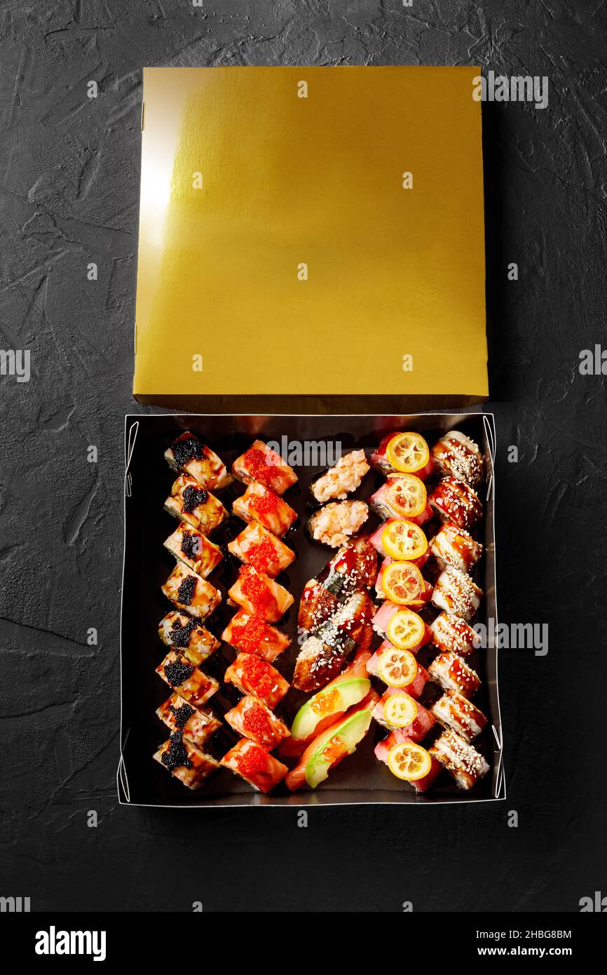 Top view of cardboard box with uramaki, nigiri sushi and gunkan maki ...