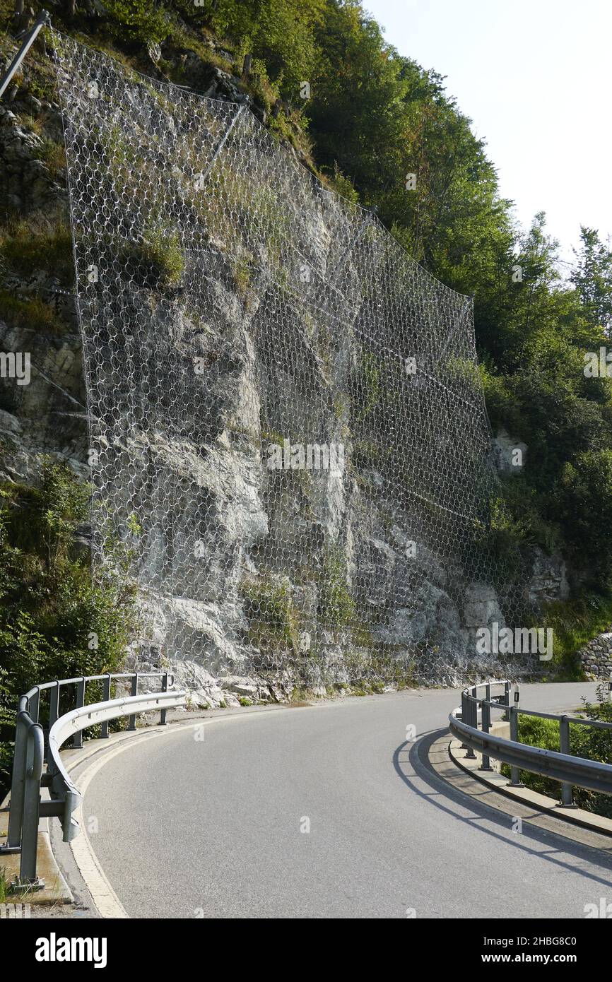 A vertical shot of a curving road in the countryside with rockfall ...