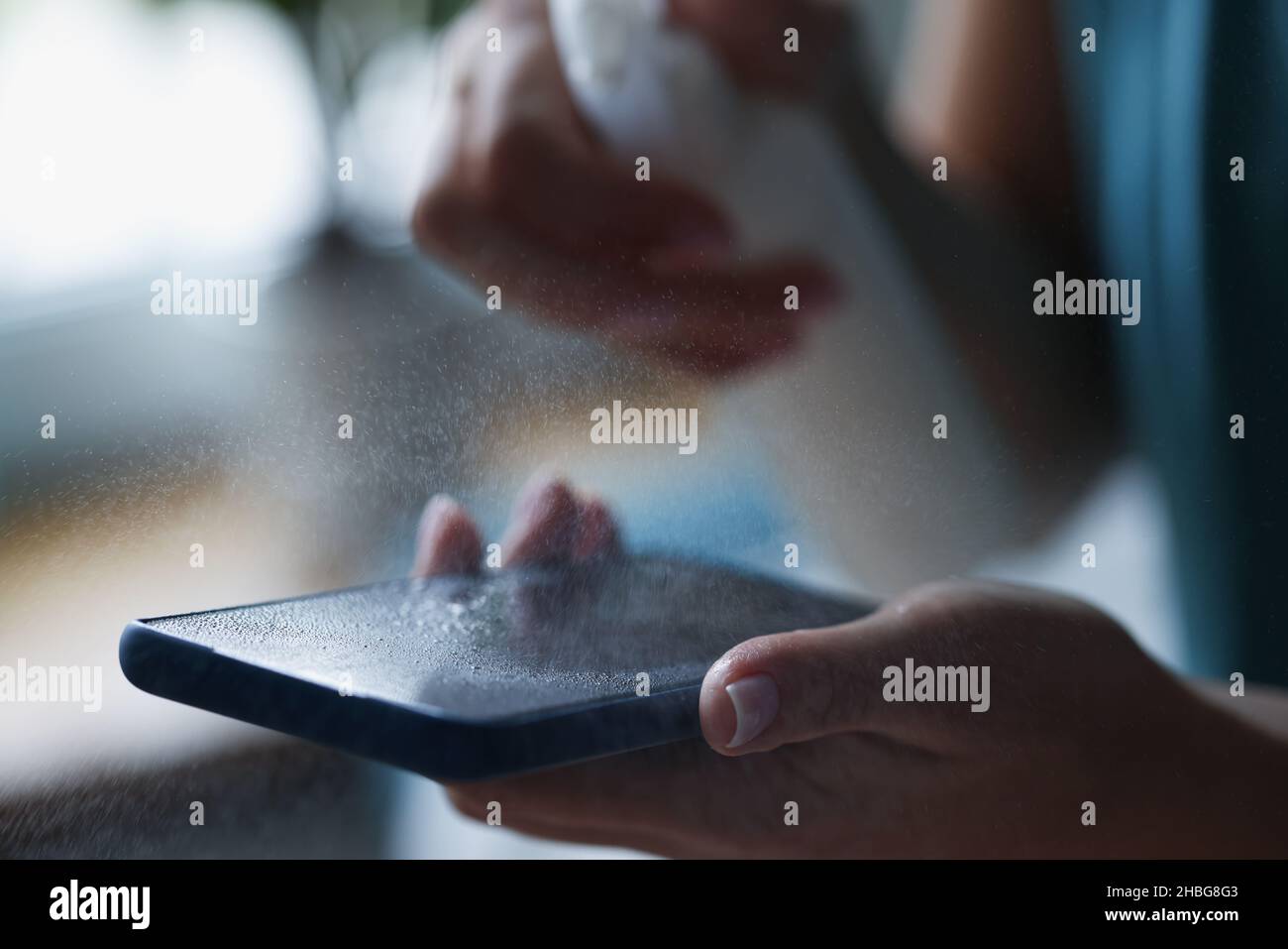 Spray antiseptic on mobile phone screen, antibacterial and disinfecting ...