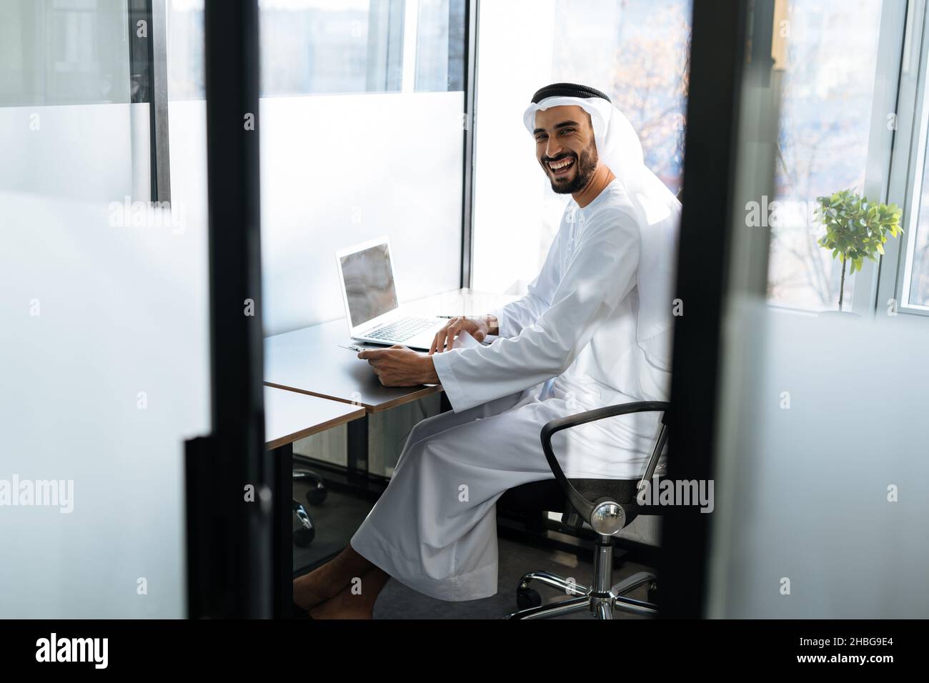 handsome man with dish dasha working in his business office of Dubai ...