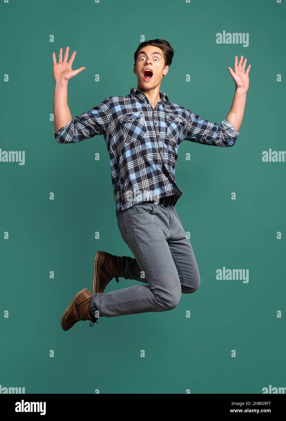 Full-length portrait of young shocked, surprised man, student jumping ...
