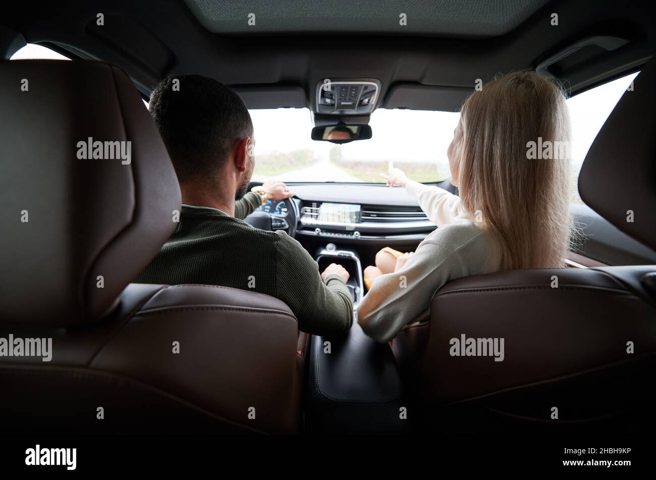 Back view of man and woman traveling in car. Beautiful young couple ...