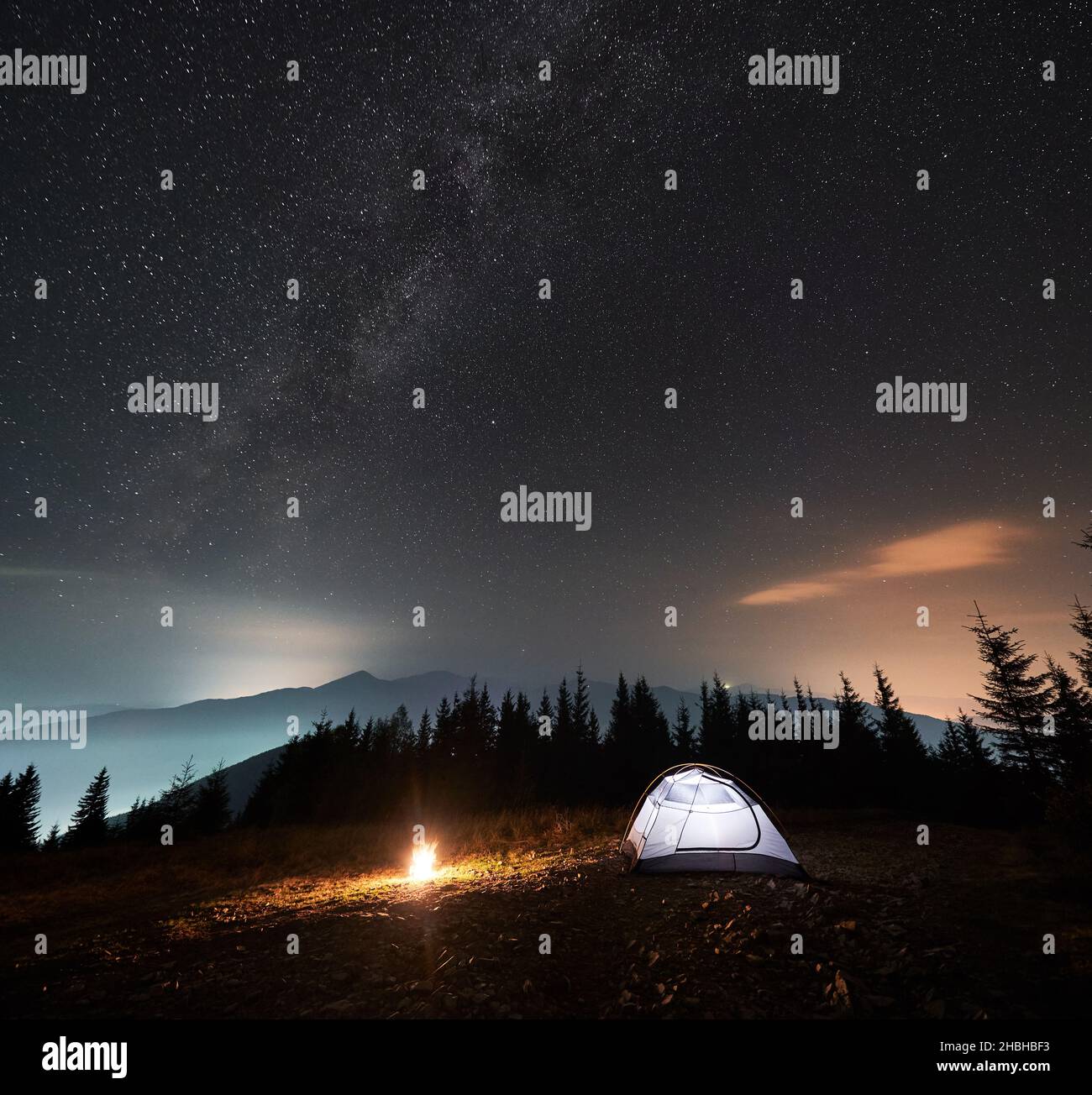 Magnificent view of night starry sky with Milky way over grassy hill ...