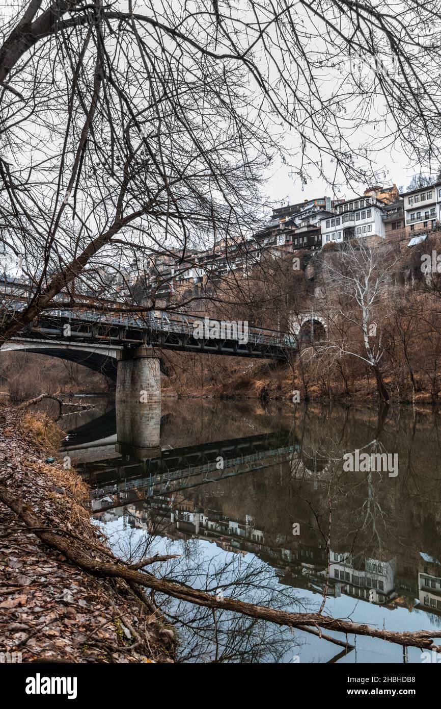 A railroad bridge that goes over the lake into the tunnel in a mountain ...