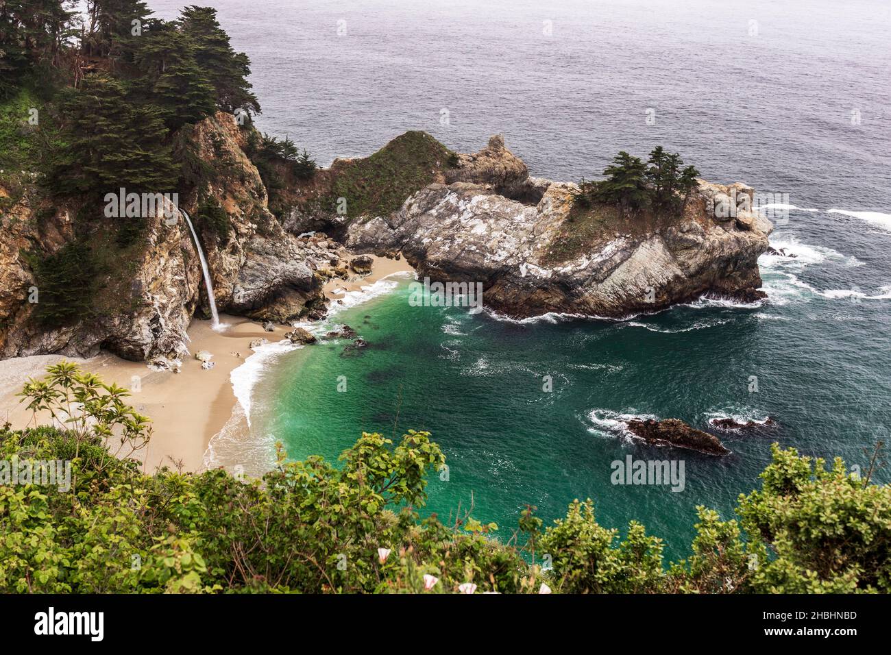 A bird's eye view of a beautiful waterfall crashing onto the beach ...