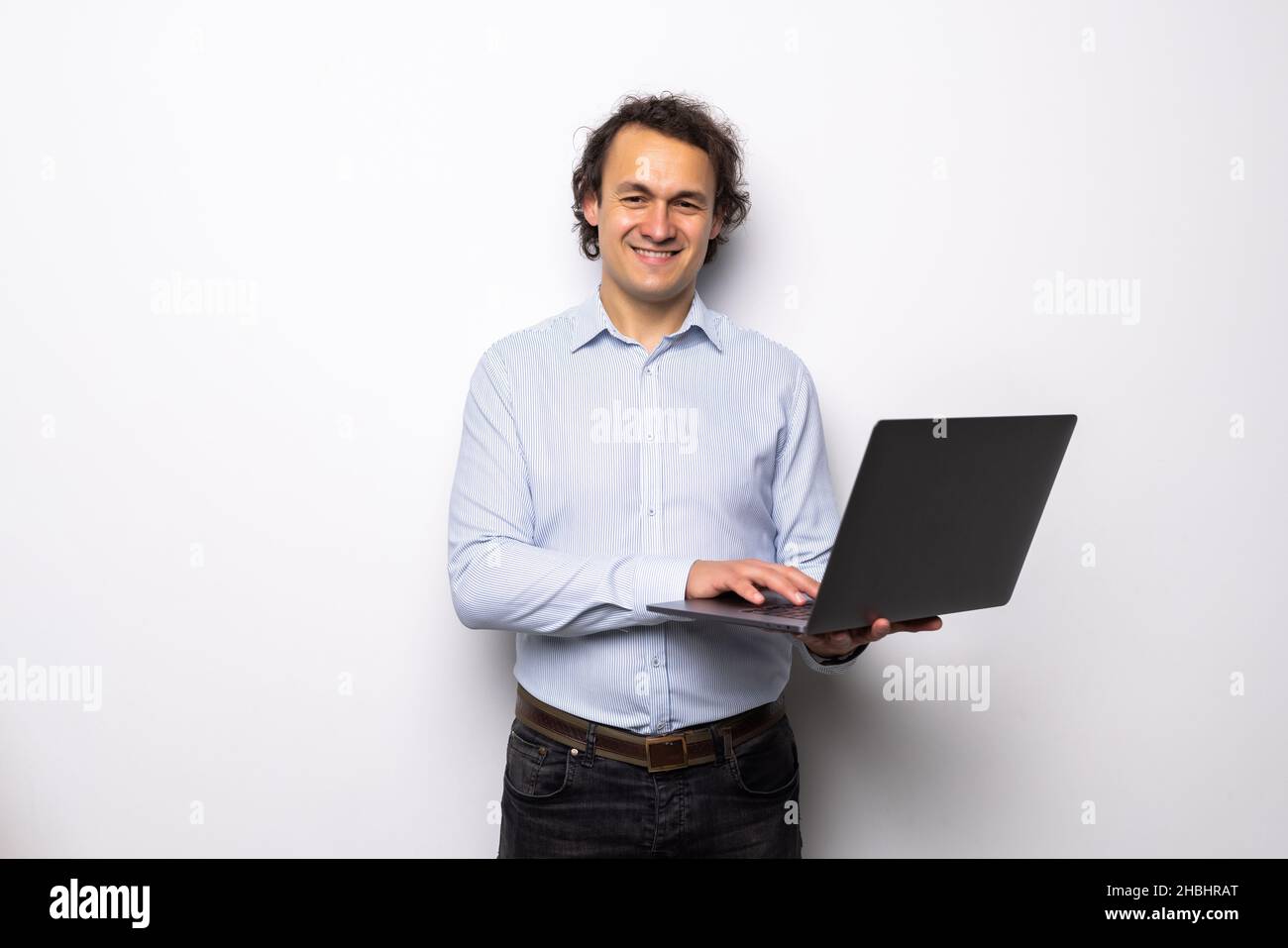 Always ready to help. Confident man holding laptop and smiling while ...