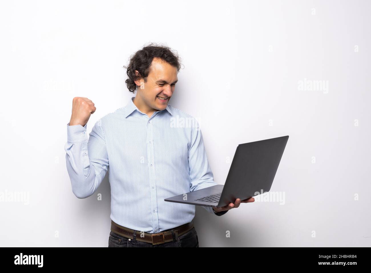 Happy professional man gesturing and looking at a laptop computer ...