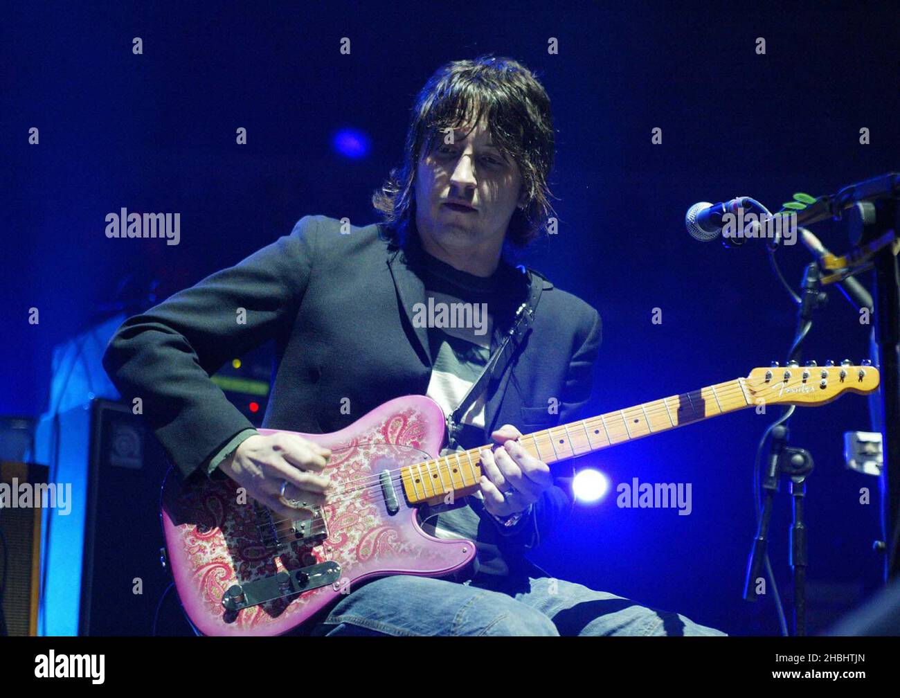 Oasis guitarist performing live on stage at the Teenage Cancer Trust ...