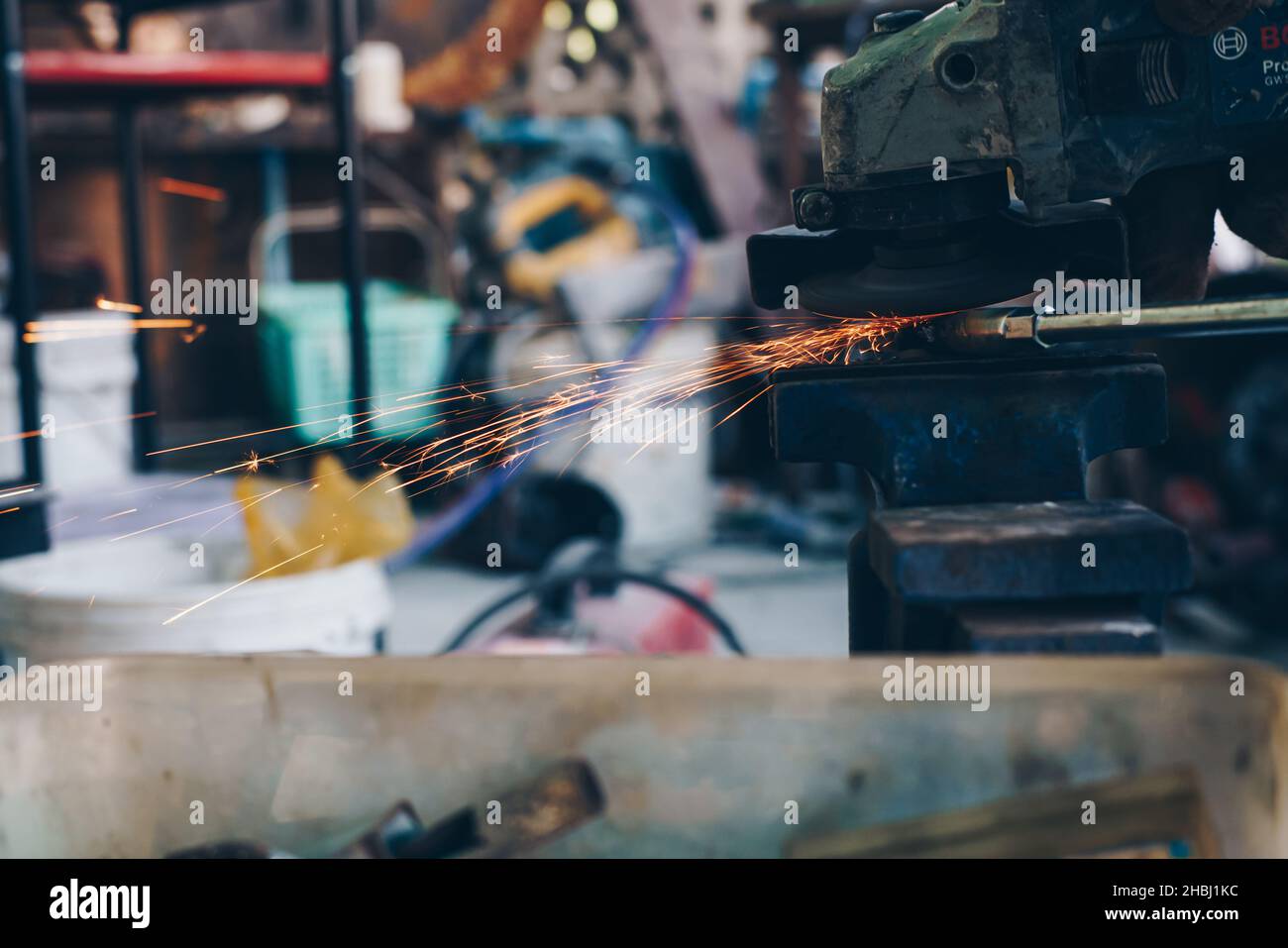 Mechanical man hand use electric grinder with flame sparks on metal ...