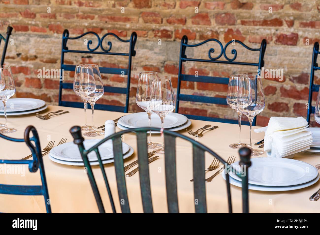 A festive table setting with empty wine glasses and white plates during ...