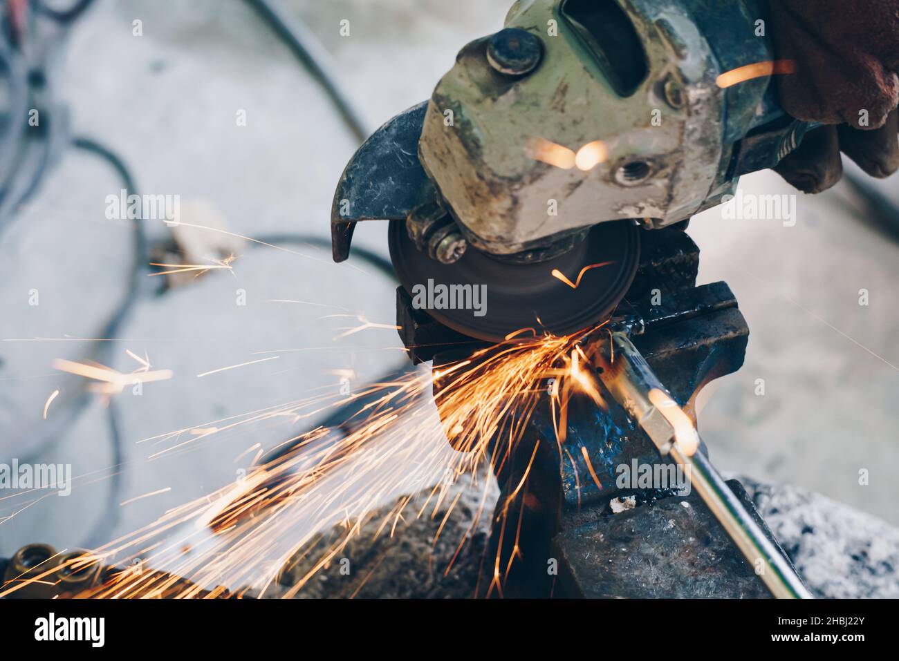 Mechanical man hand use electric grinder with flame sparks on metal ...