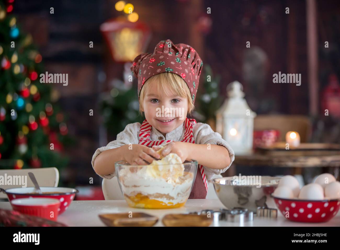 Cute blond child, toddler boy, baking christmas cookies at home, having ...
