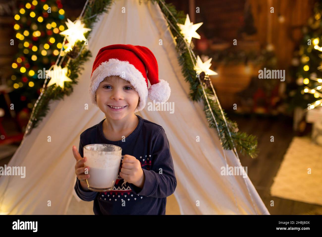 Beautiful blond toddler child, boy, drinking hot cocoa with wipped ...