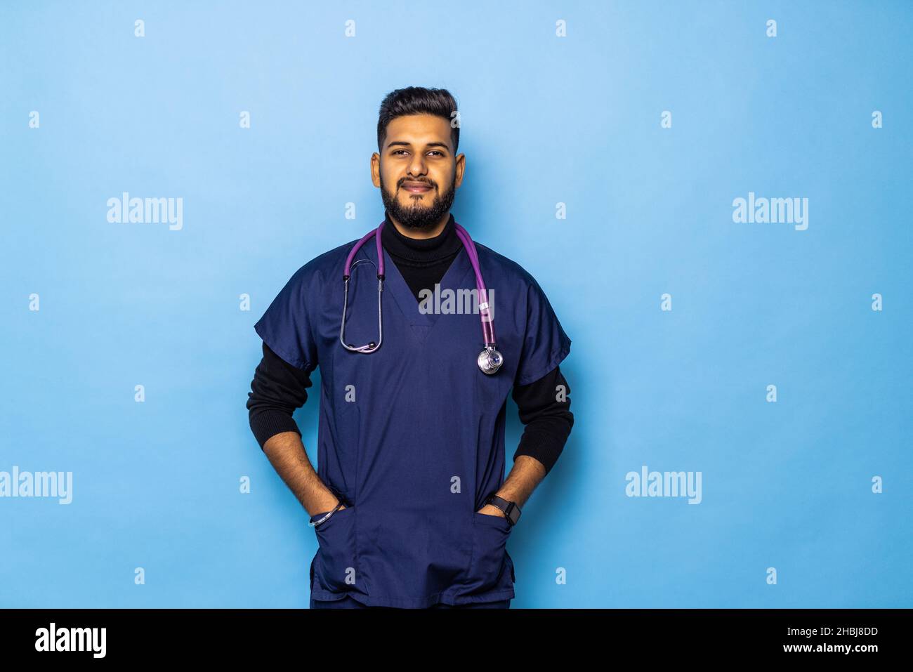 A indian surgeon standing setting his gloves to start the surgery ...