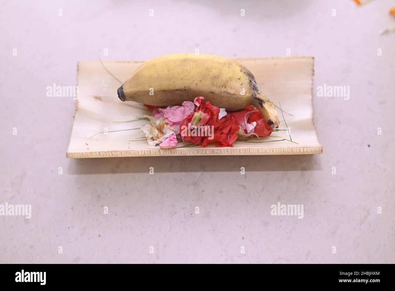 Shot of the banana and rose flowers kept on the type of a leaf for kids ...