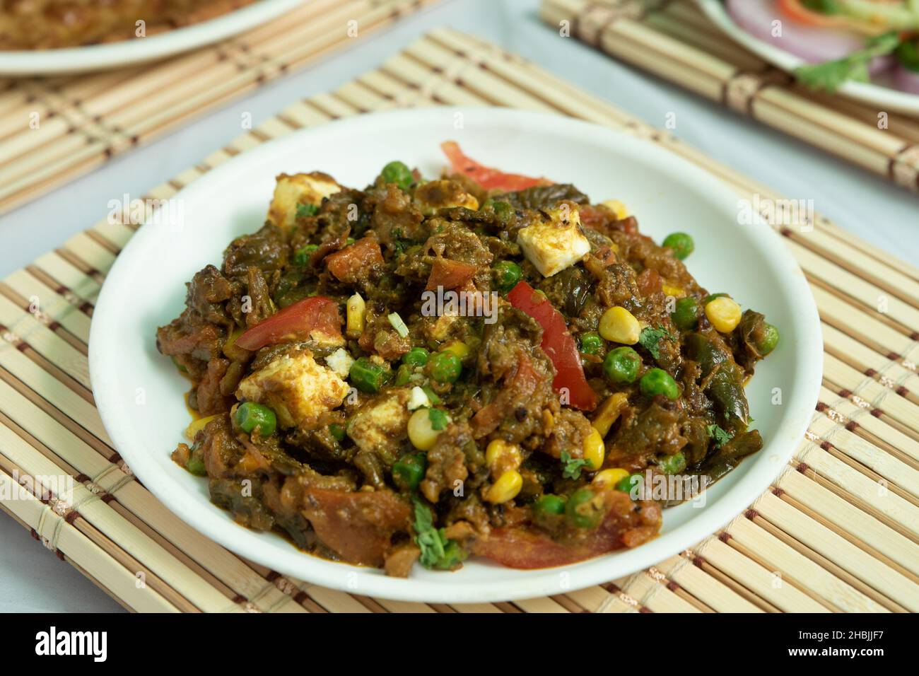 Shot of the vegetable paneer mutter masala served on the white plate ...