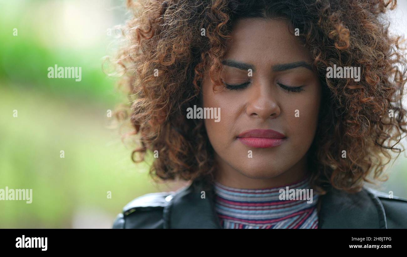 Black African woman taking a deep breath breathing outside closing eyes ...