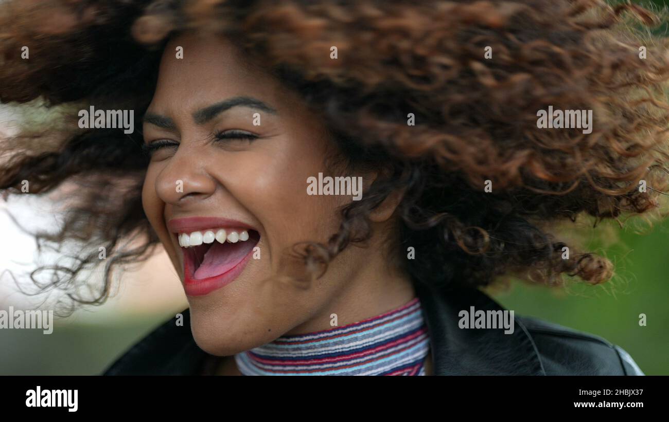 Carefree latina black woman shaking hair and smiling at camera Stock ...
