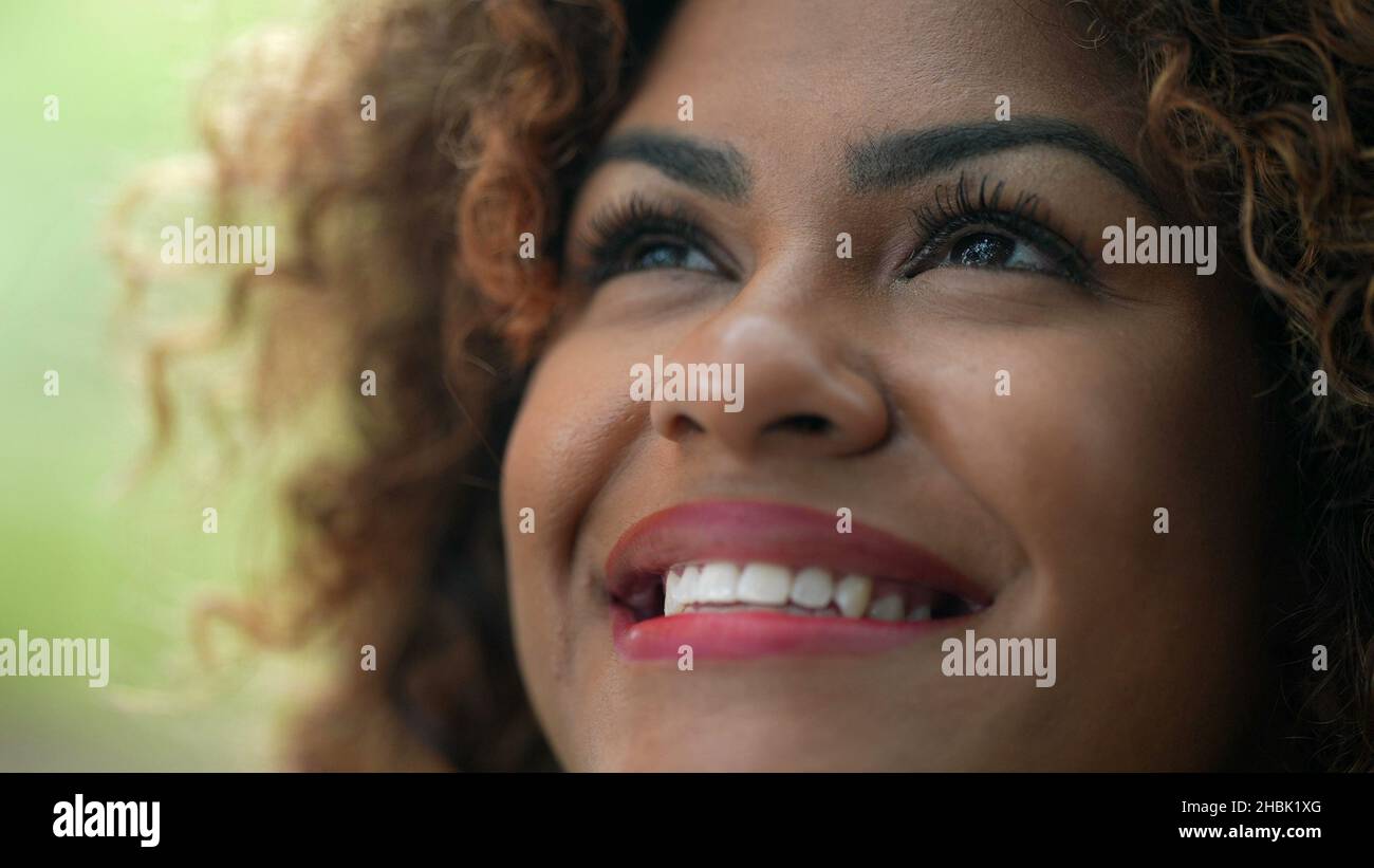 Happy Brazilian woman smiling at sky with HOPE Stock Photo - Alamy