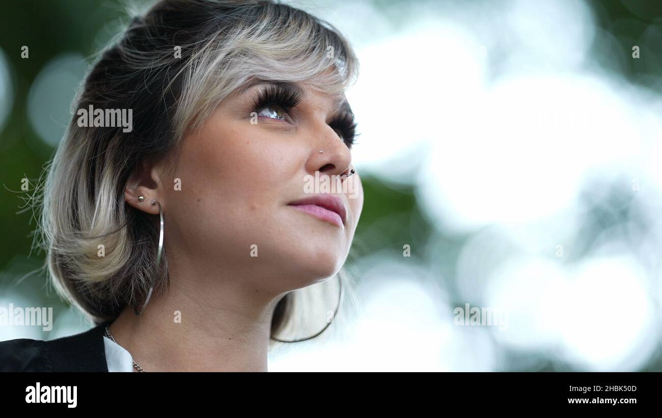 Pensive woman contemplating decision outside. authentic thinking ...