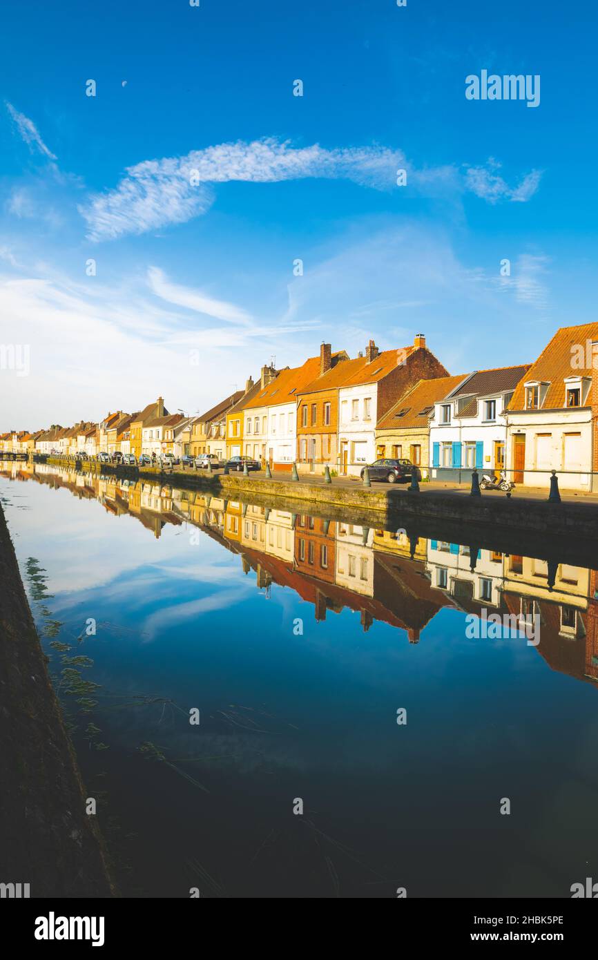 Line of Traditional buildings with cars standing and canal in ...