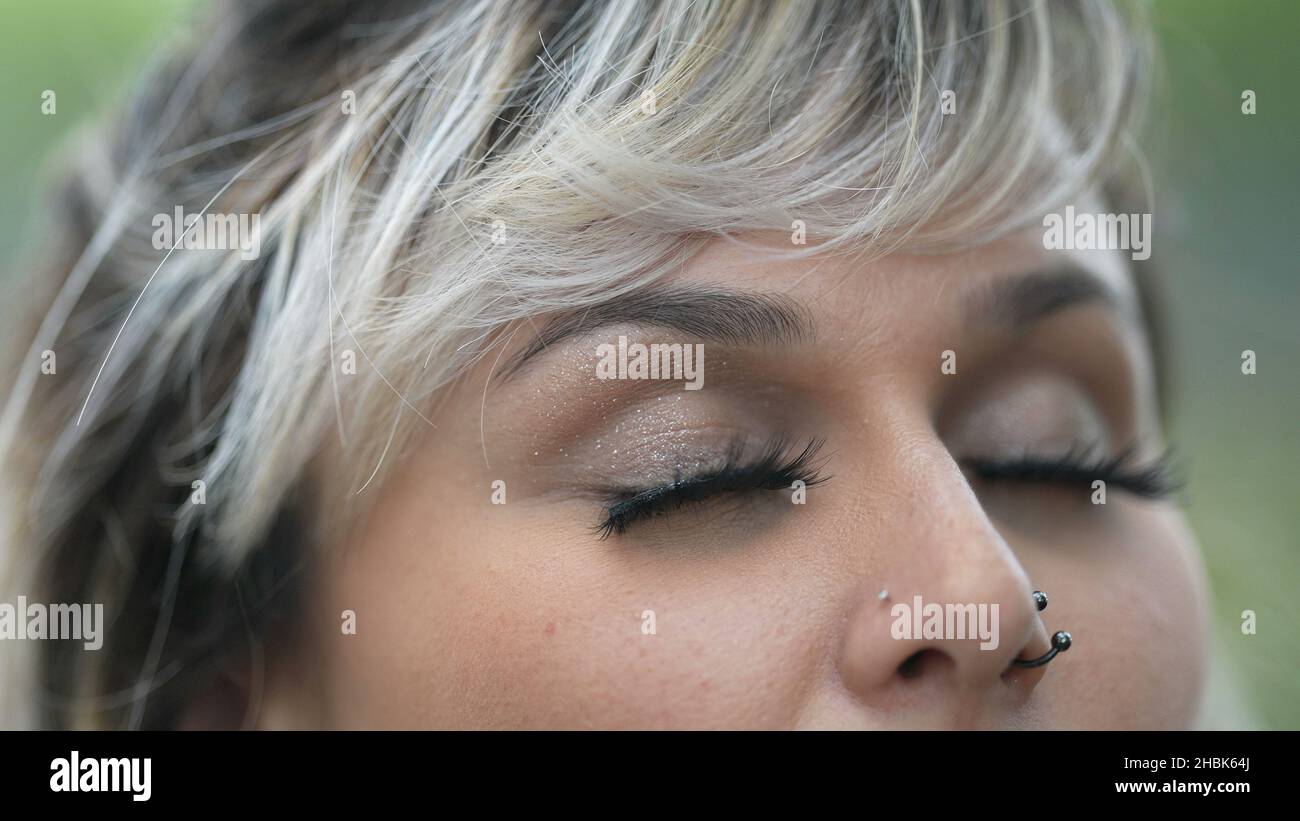 Person closing eyes in meditation. Woman opening eye to sky smiling ...