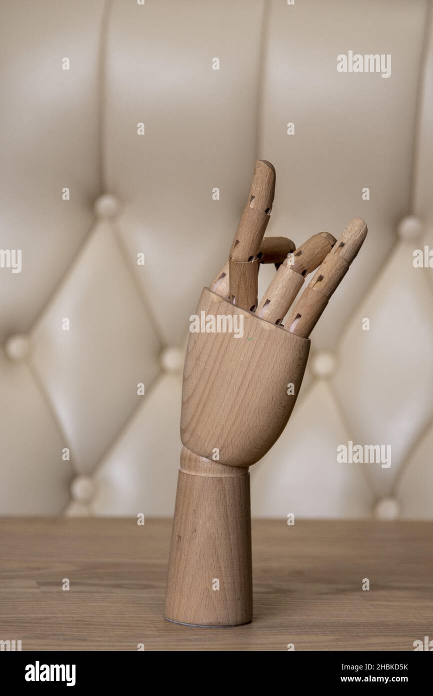 A wooden model of a human hand on a table against the background of a ...