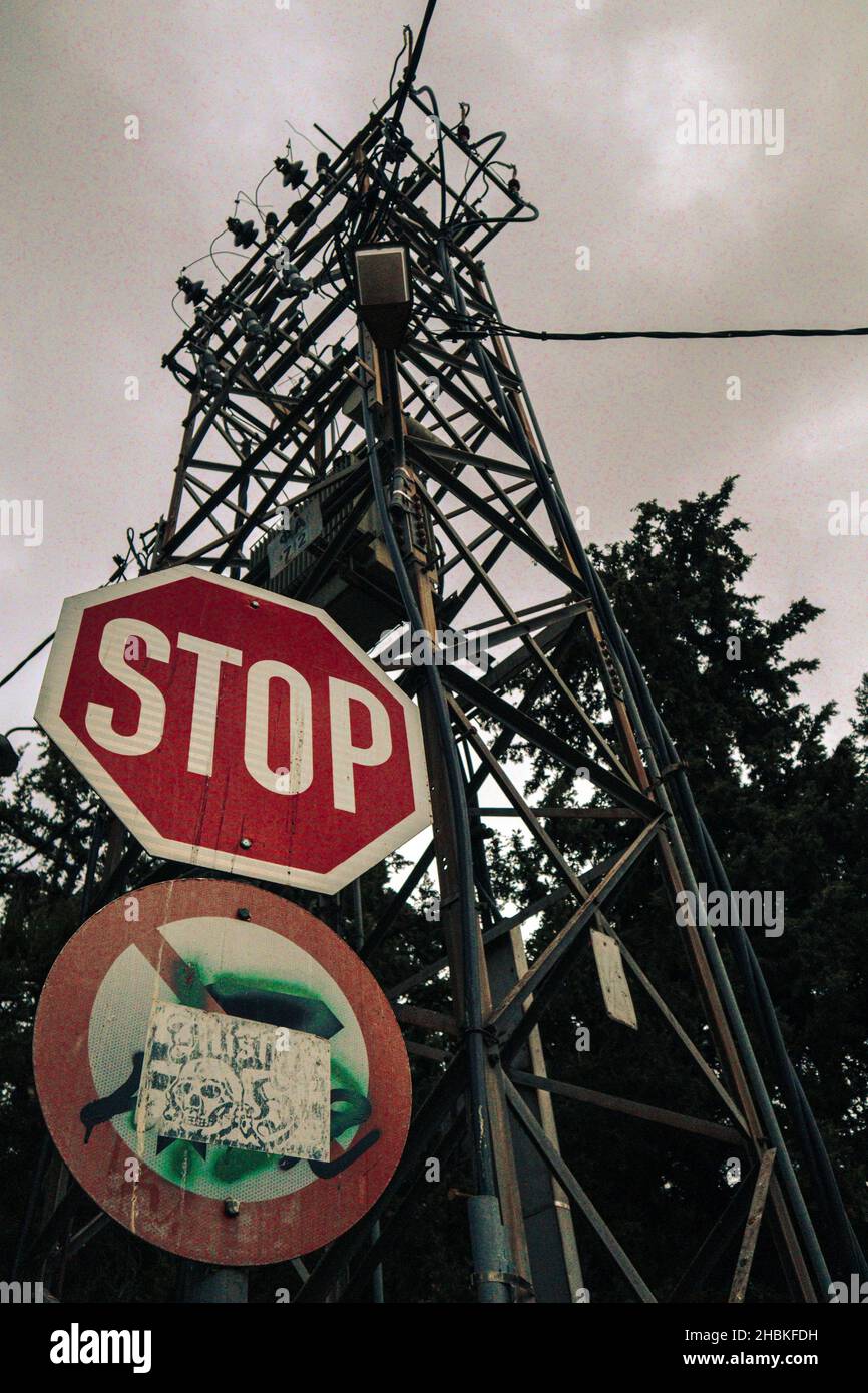 A vertical low angle shot of the stop sign against the electric tower ...
