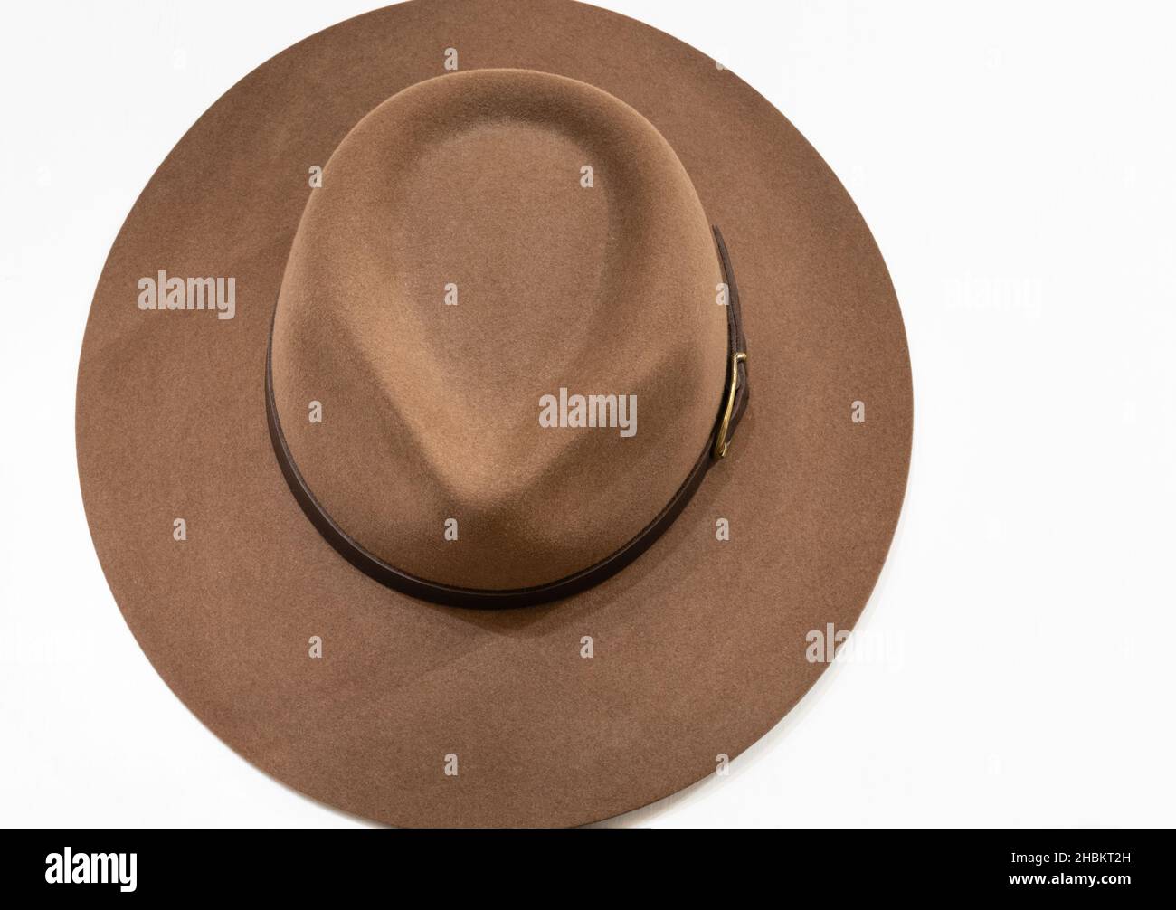 Classic cowboy brown felt hat with strap and copper closure on white ...
