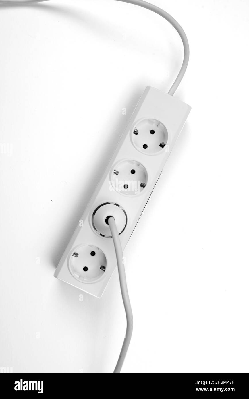 Electric plug into a white power socket extension isolated over white ...