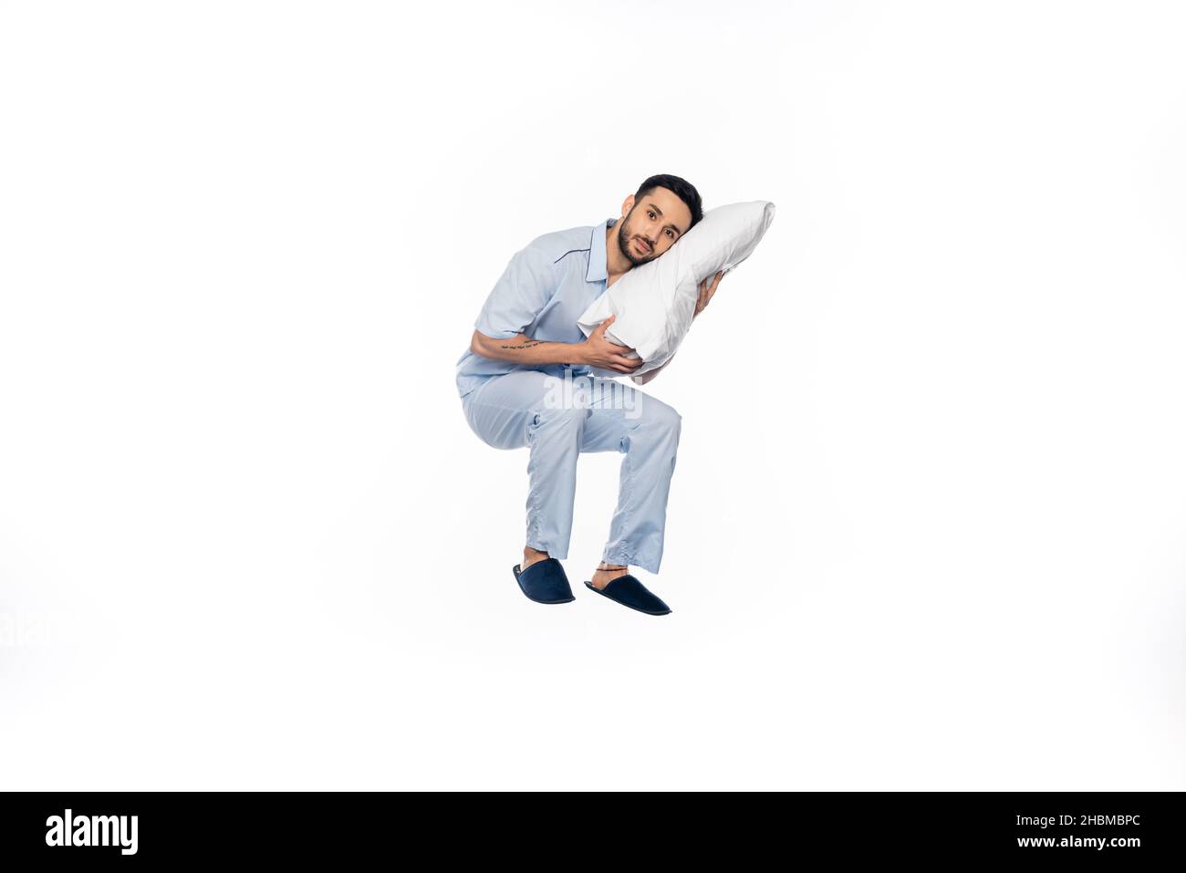bearded man in pajamas levitating with pillow on white Stock Photo - Alamy