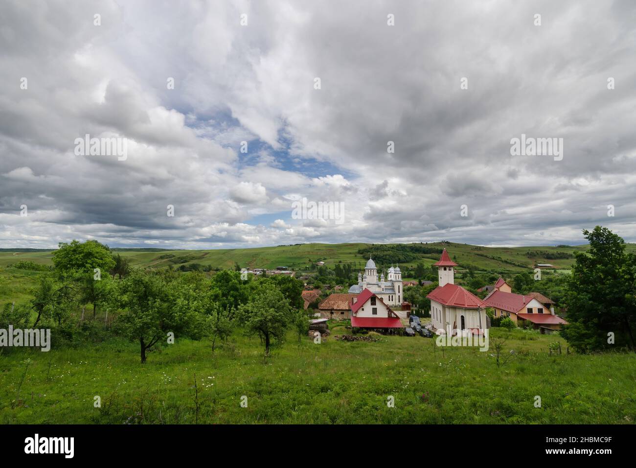 Landscape with green hills, charming churches and dramatic sky in ...