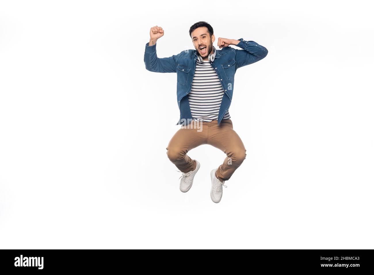 happy man with wireless headphones levitating and cheering isolated on ...